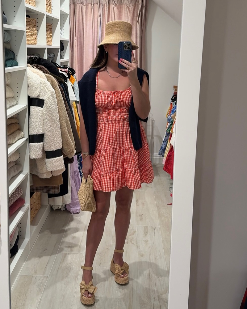 Mirror selfie featuring red gingham sundress with straw hat%2C wedge sandals and navy sweater%2C styled in walk-in closet