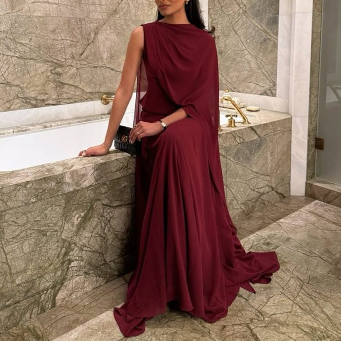 Elegant burgundy evening gown drapes gracefully on a model, complemented by a chic black handbag against a luxurious marble backdrop.