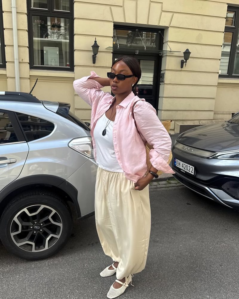Pink button-down shirt with white tank and cream maxi skirt%2C styled with woven flats and sunglasses for relaxed summer street style