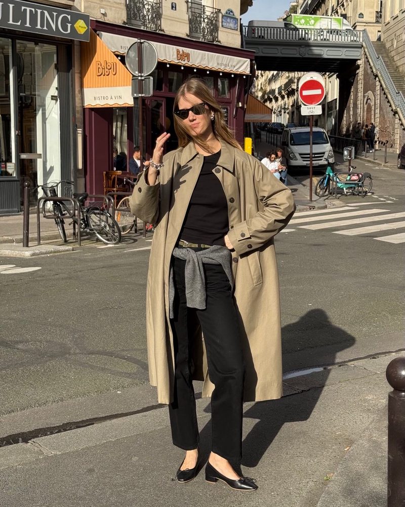 Sophisticated outfit featuring a cream trench coat over a fitted black top%2C paired with black trousers and chic black block heels