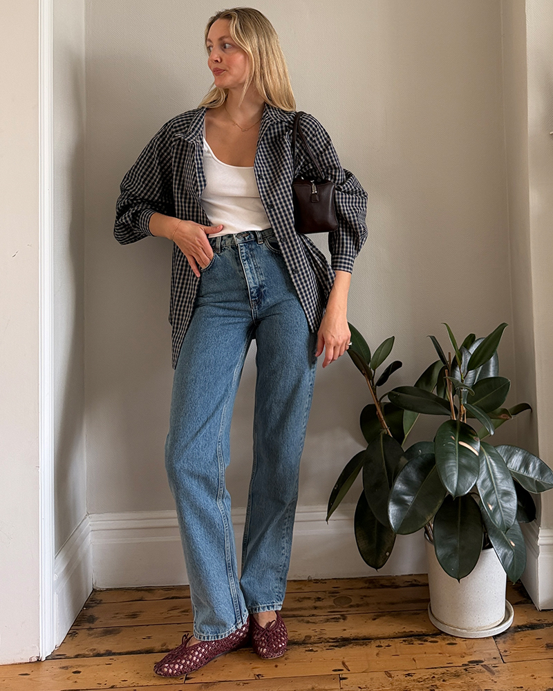 Checkered overshirt with white tank%2C blue straight-leg jeans%2C woven flats and brown mini bag styled indoors