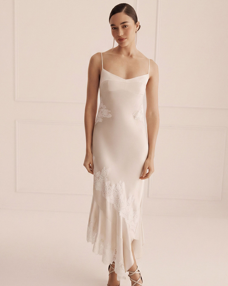Ivory lace-trim slip dress with delicate spaghetti straps and strappy heels against a soft neutral studio backdrop