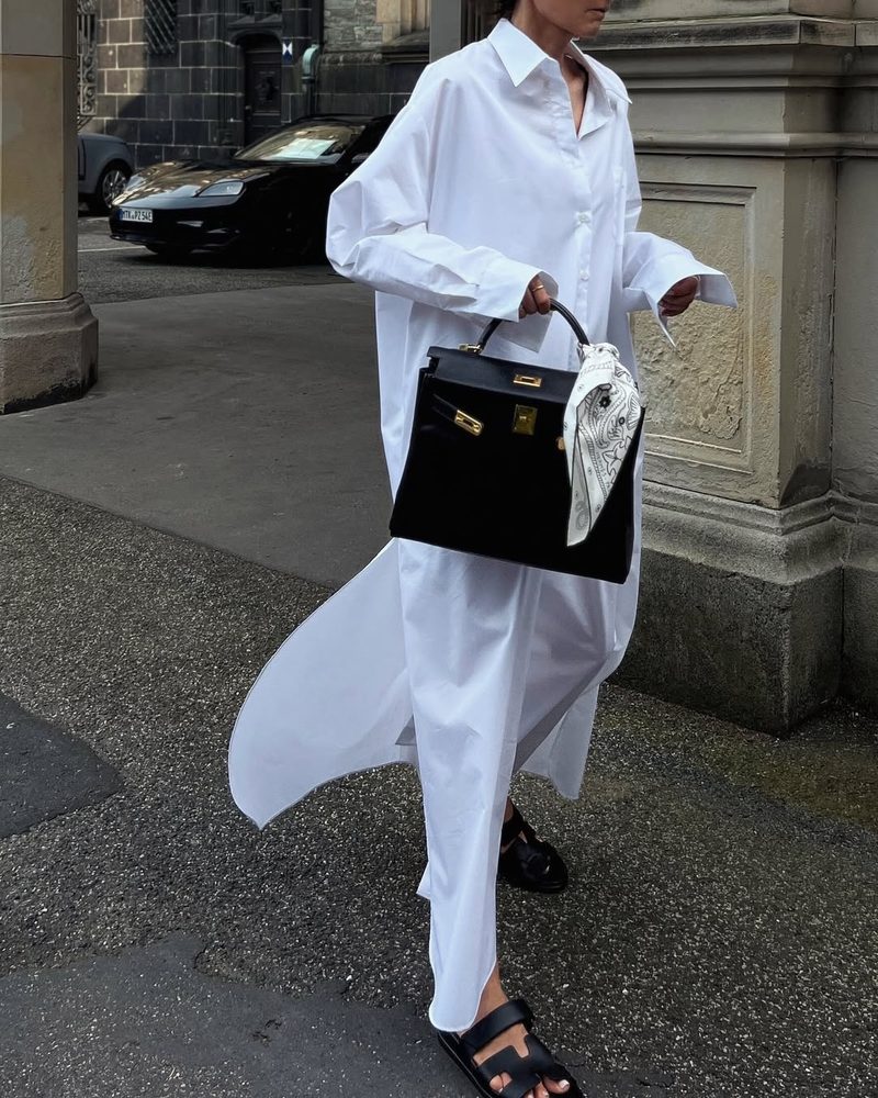 White oversized shirt dress styled with black leather sandals and Herm%C3%A8s Kelly bag%2C finished with silk scarf for chic street style