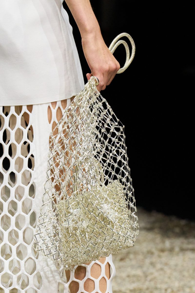 Crystal-embellished mesh net bag with loop handle paired with a white cutout dress for a modern evening look