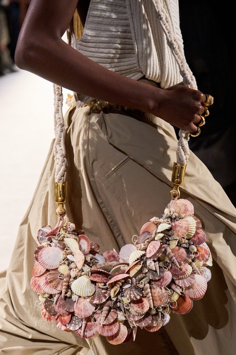 Balmain seashell shoulder bag with braided strap, paired with ribbed knit top and beige skirt for coastal summer runway style