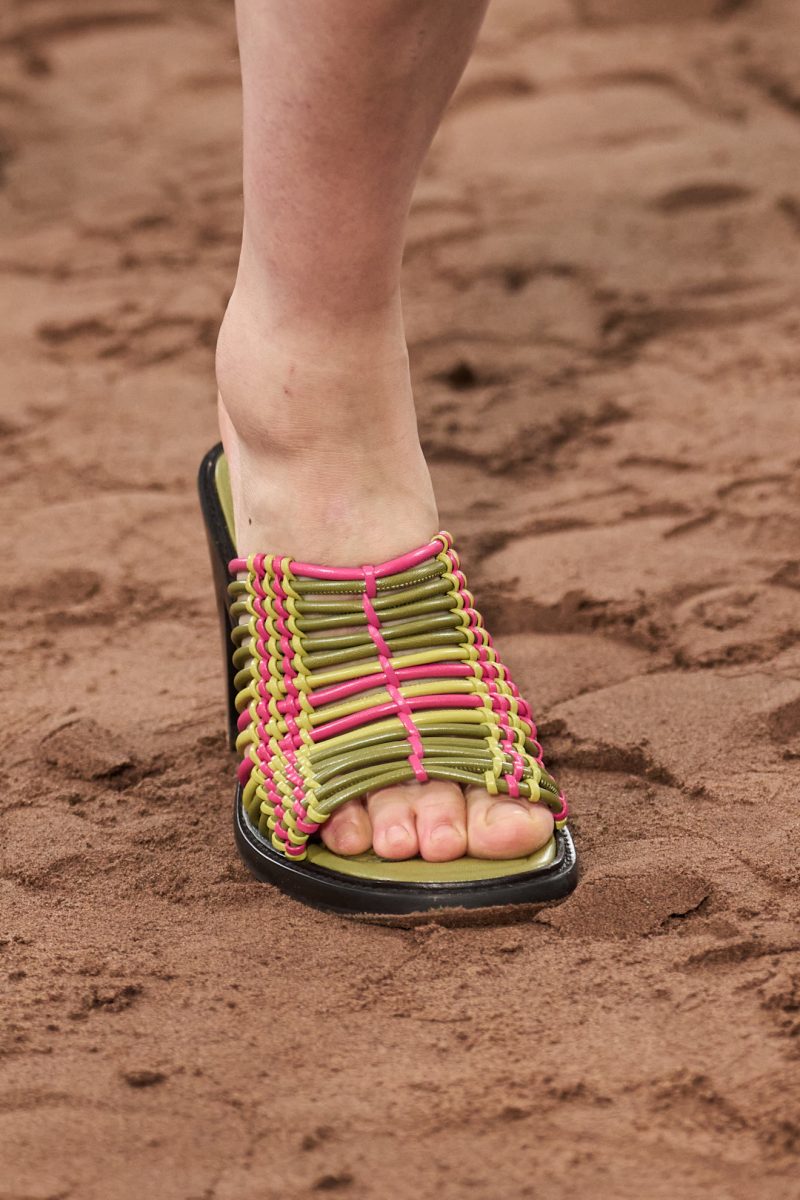 Burberry spring summer 2026 woven mule sandal in olive green and pink rubber detailing with square toe on sandy runway