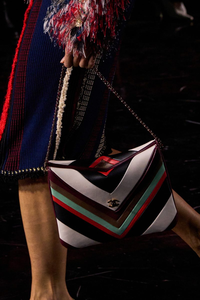 Chanel striped leather shoulder bag with chevron panels and chain strap, styled with a textured knit runway outfit