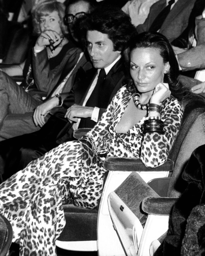 Diane Von Furstenberg showcases a striking leopard print wrap dress%2C complemented by bold bangles%2C capturing timeless elegance in a chic setting