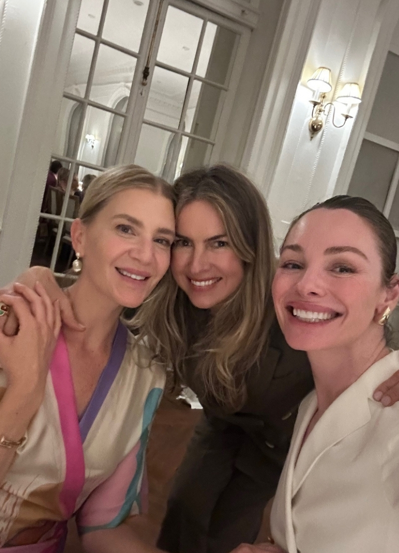 Three women in chic evening outfits with statement earrings, styled indoors in a softly lit elegant space