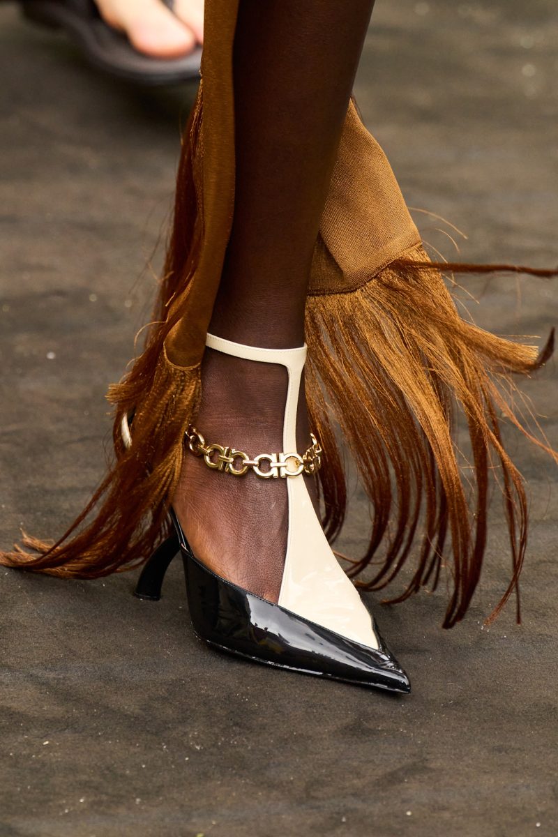 Ferragamo black and white patent leather T-strap heels with gold chain detail and brown fringe pants on runway