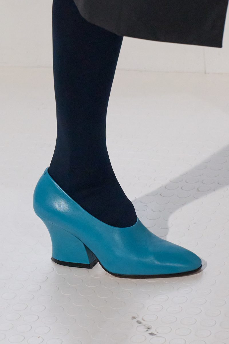 Jil Sander blue leather mid-heel pumps paired with black opaque tights for a sleek, modern look
