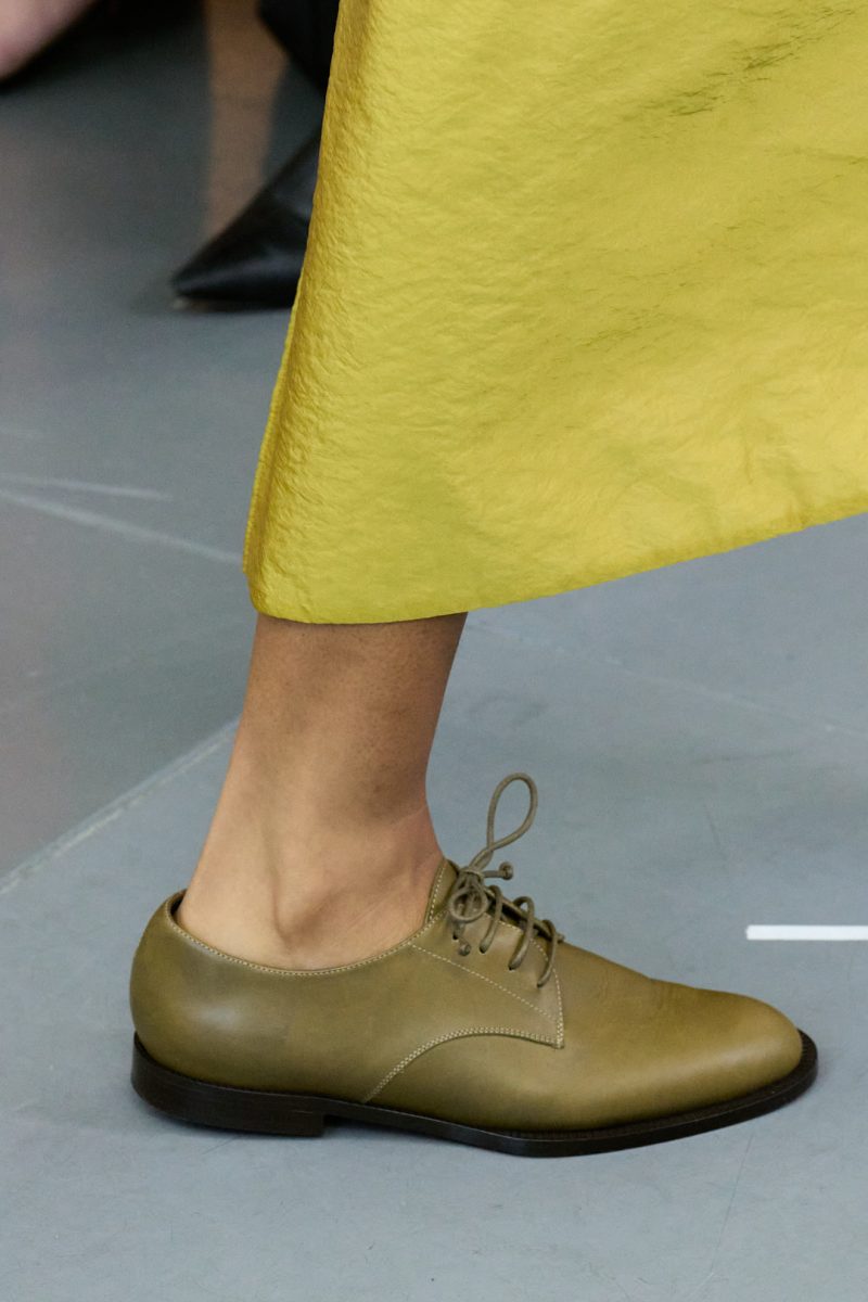Tibi olive green leather lace-up oxford shoe paired with a yellow textured midi skirt on runway