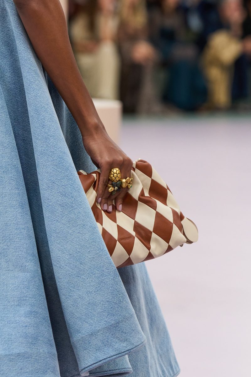 Bottega Veneta intrecciato clutch in brown and cream checkerboard leather, styled with a soft blue midi skirt and gold rings