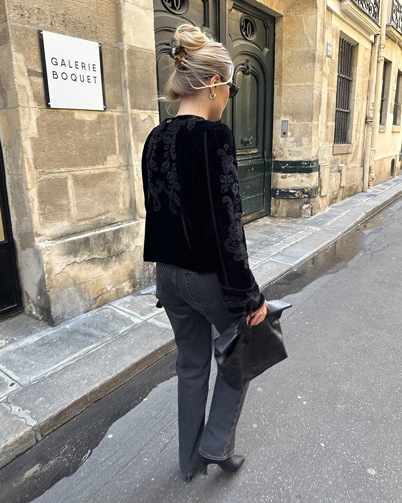 Black velvet embroidered jacket with charcoal denim and pointed boots styled on a Parisian street