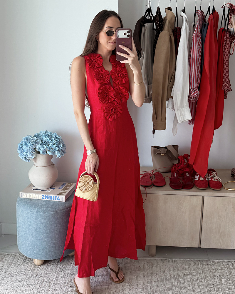 Woman in a red floral-appliqu%C3%A9 maxi dress with a woven top-handle bag and sandals%2C styled in a bright dressing room
