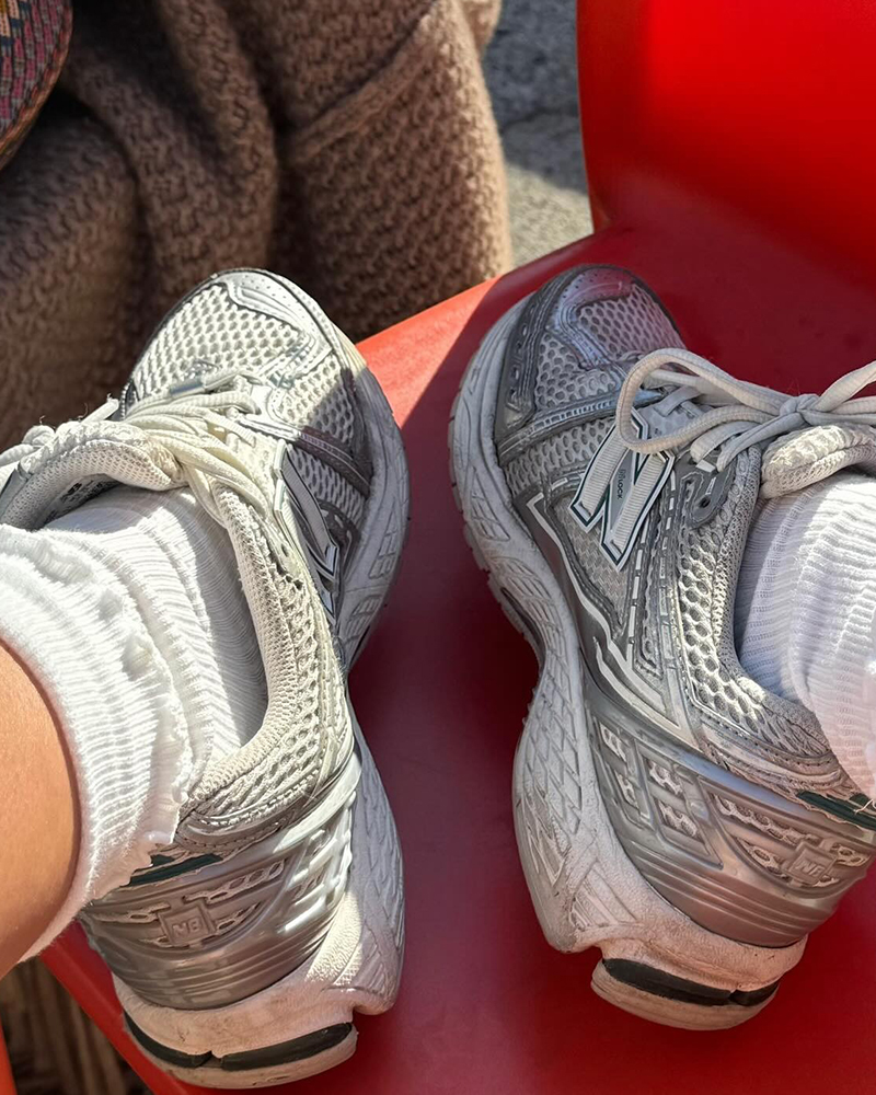 ASICS GEL-Kayano running sneakers with white crew socks%2C styled on a red lounge chair in warm outdoor sunlight