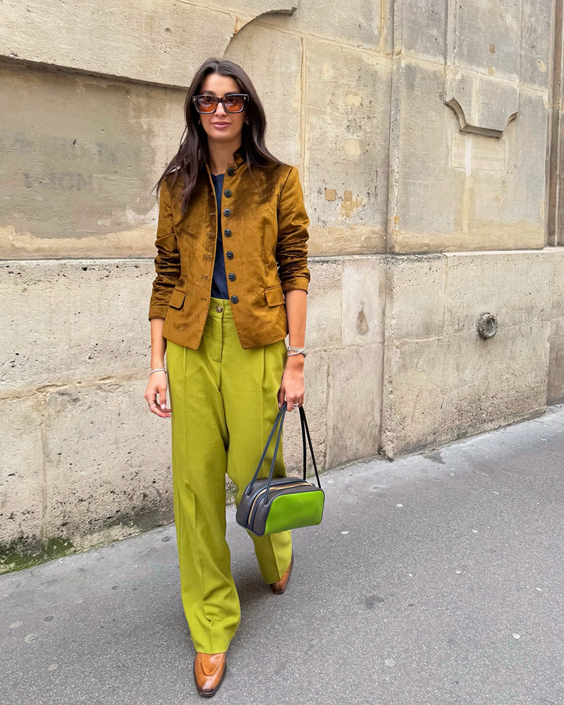 Street style look featuring a brown velvet blazer%2C chartreuse wide-leg trousers and a color-block shoulder bag on a city sidewalk