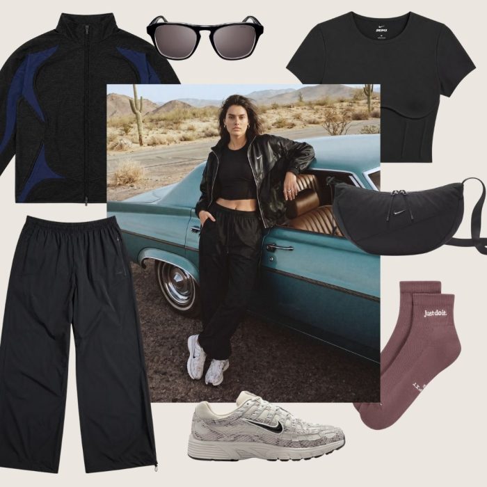 Nike activewear outfit featuring a black windbreaker, crop top and track pants with sneakers and accessories in a desert setting
