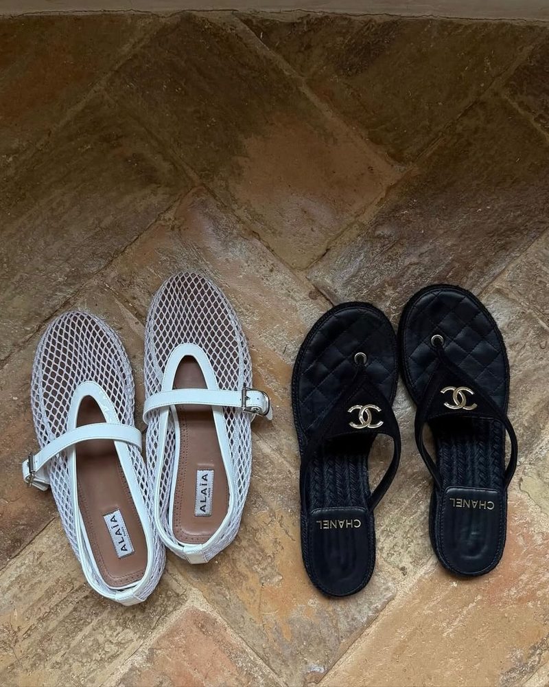 White Ala%C3%AFa mesh Mary Jane flats with buckle strap and black Chanel quilted leather thong sandals with gold logo on tiled floor%0A%0A