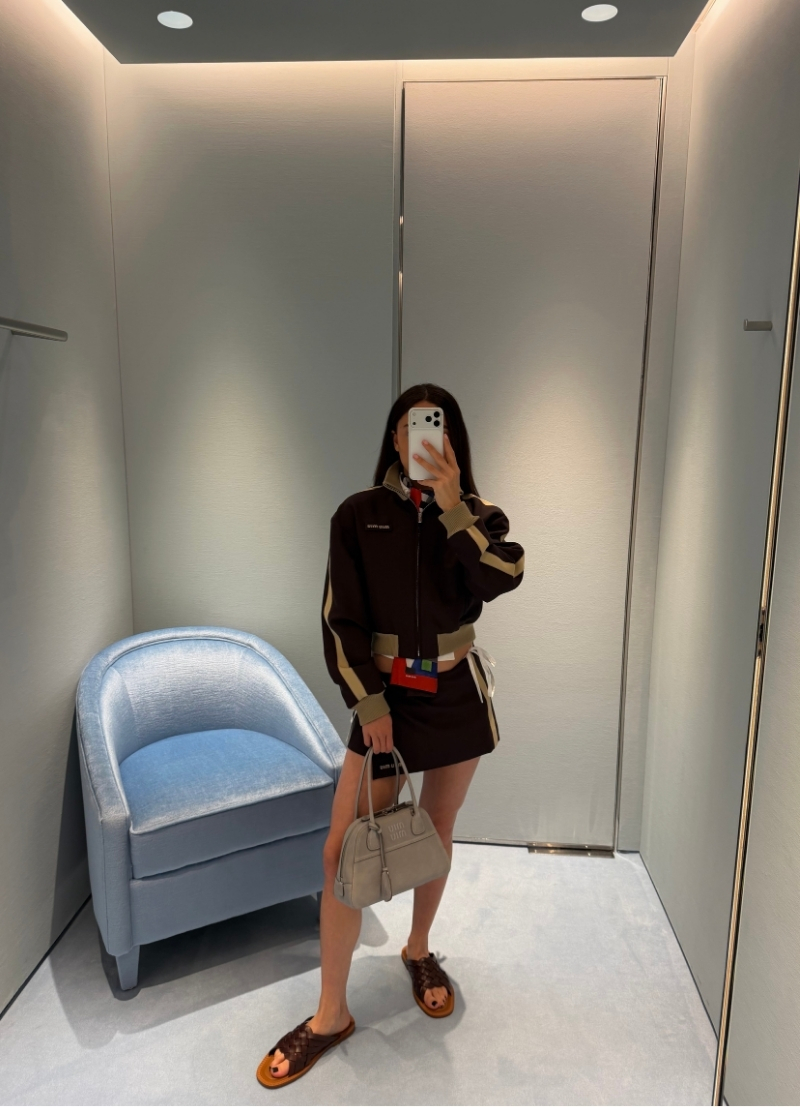 Miu Miu sporty mini dress with contrast trim, leather handbag and woven slides, styled in a minimalist fitting room