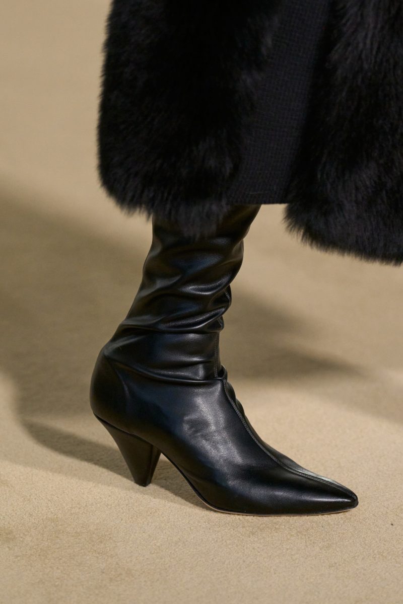 Black leather slouchy mid-calf boots with pointed toes and cone heels paired with a black fur coat for fall fashion