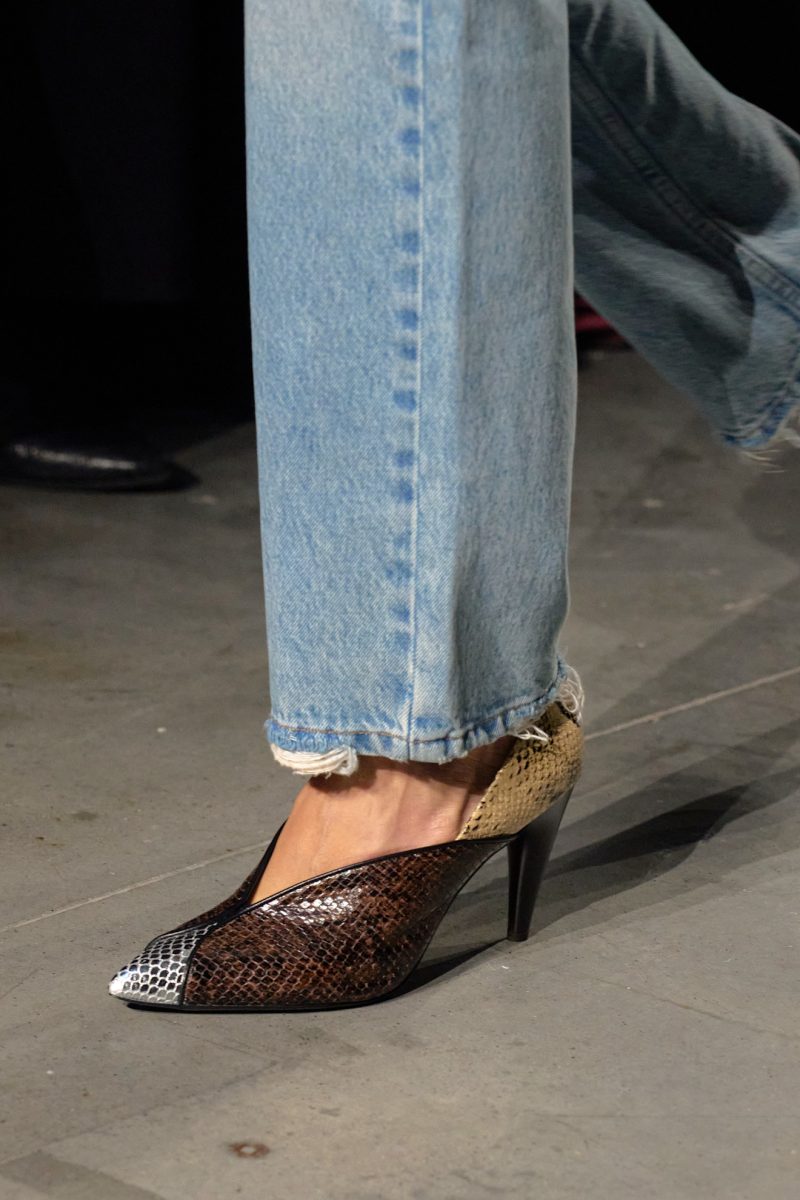 Pointed-toe high heel shoes in mixed snakeskin patterns paired with light blue frayed hem jeans