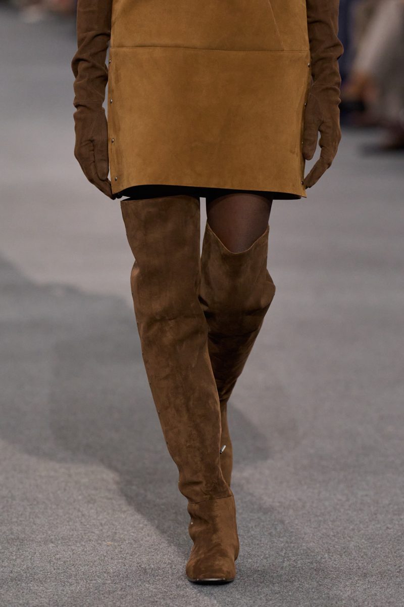Brown suede thigh-high boots paired with matching suede mini skirt and gloves in a fall fashion look