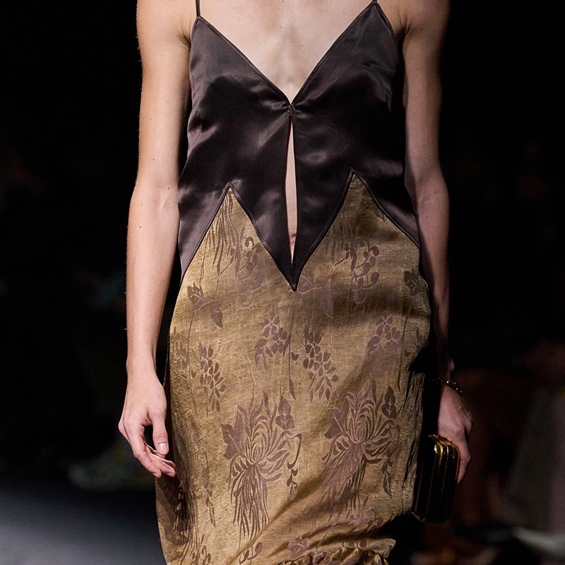 Fall runway details featuring a red croc-effect bag, satin floral dress and snakeskin pumps on the catwalk