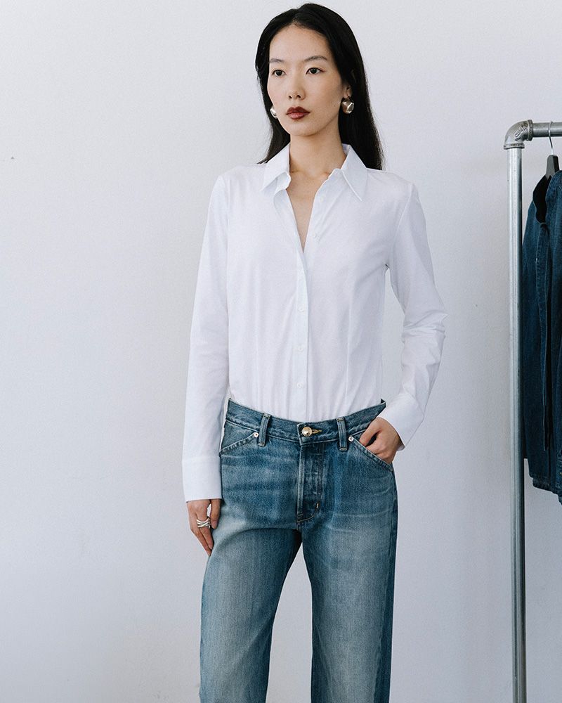 Crisp white button-down shirt tucked into mid-wash straight-leg jeans%2C styled in a clean studio setting