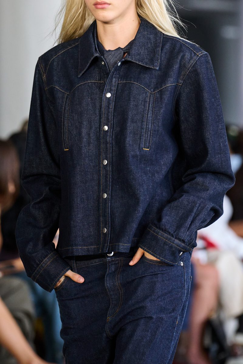 Model wearing dark indigo denim jacket with snap buttons and matching high-waisted jeans in a casual fall outfit