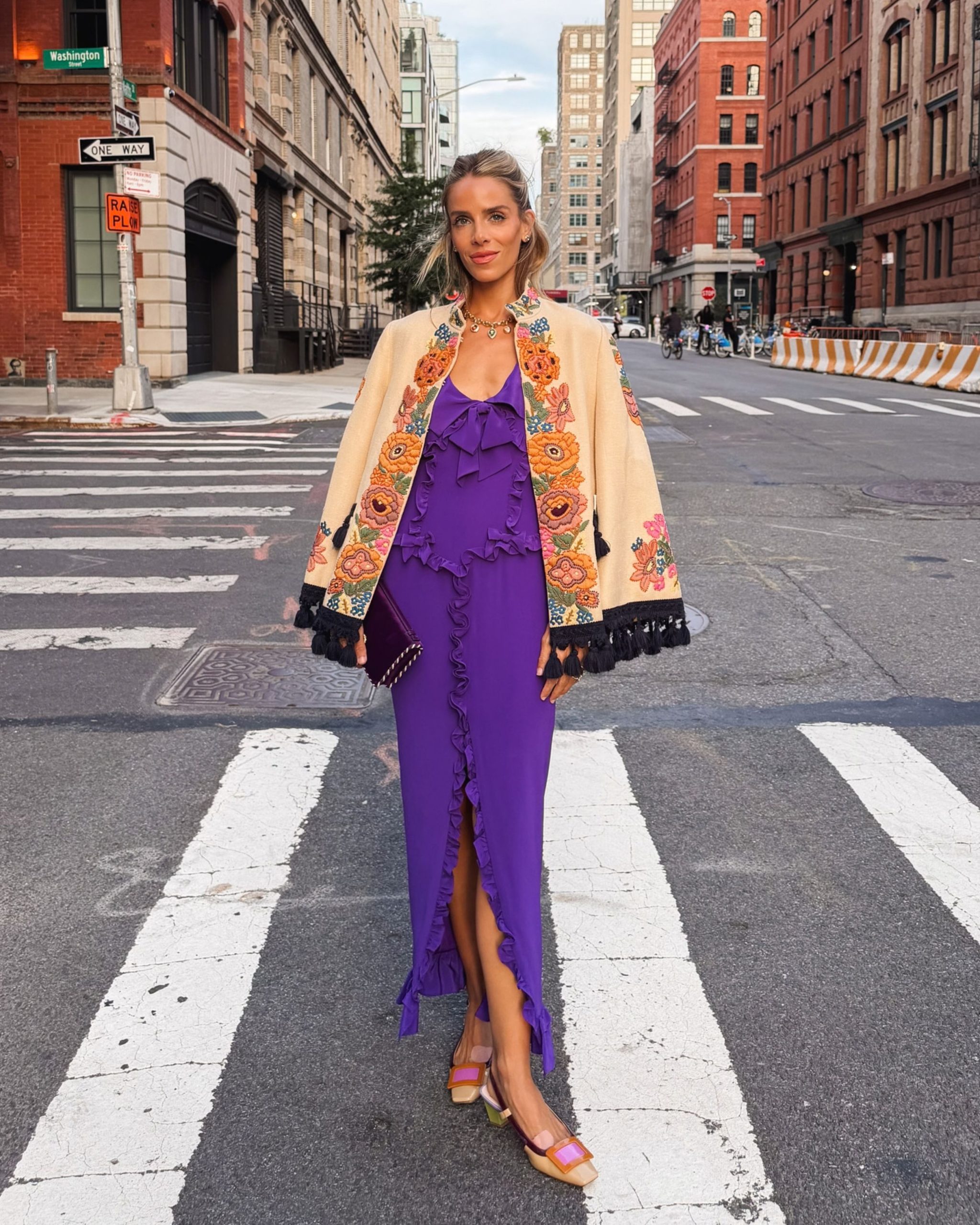 Maximalist style featuring a vibrant purple ruffle dress paired with a floral embroidered shawl%2C complemented by a chic clutch and colorful sandals