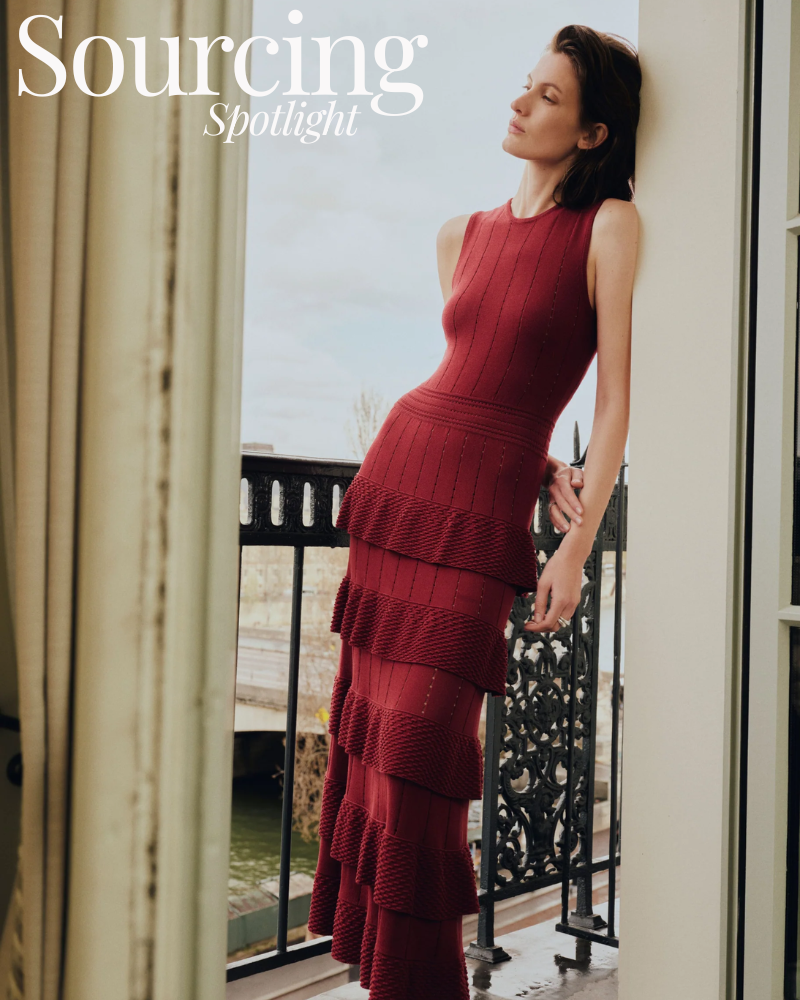 Lela Rose sleeveless burgundy knit dress featuring ribbed texture and tiered ruffles%2C elegantly posed against a balcony backdrop